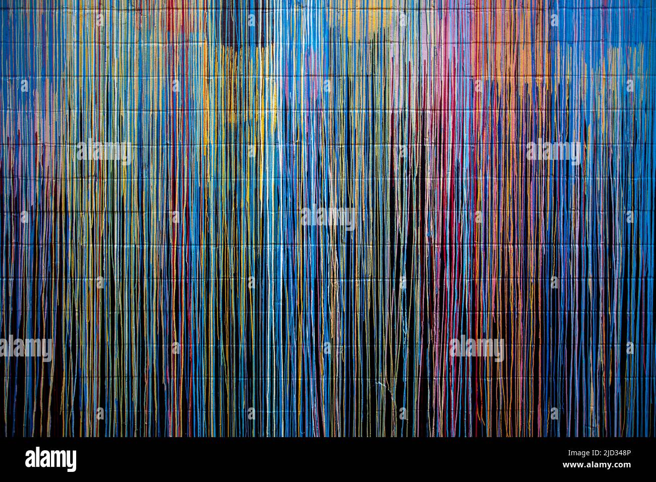 Multiple colored Paint drips streaks down a brick wall Stock Photo - Alamy