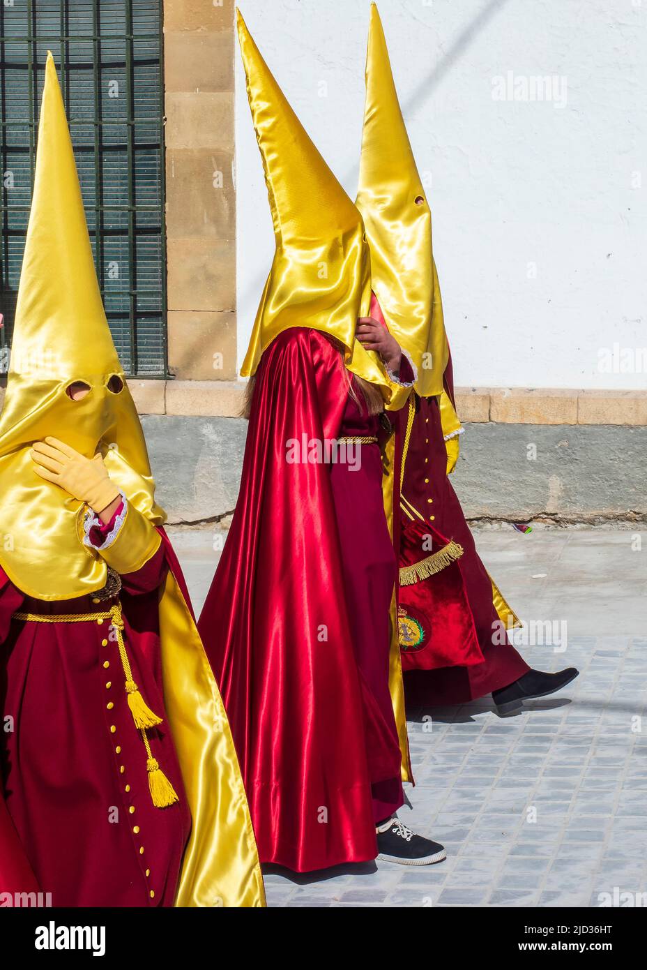 Cofrades in their traditional costumes with capirote, parading through ...