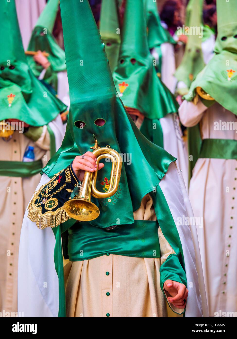 Cofrades in their traditional costumes with capirote, parading through ...