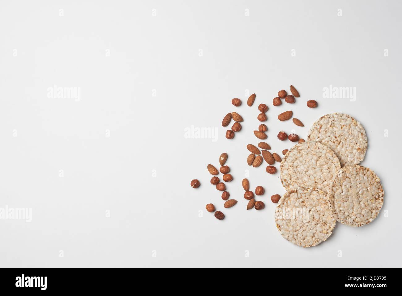 Stack of rice cakes and nuts on white background. Healthy snacks Stock ...