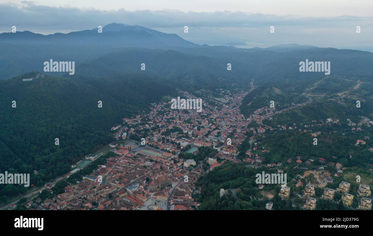 Drone top aerial view of Brasov town with parks and surrounding hills ...