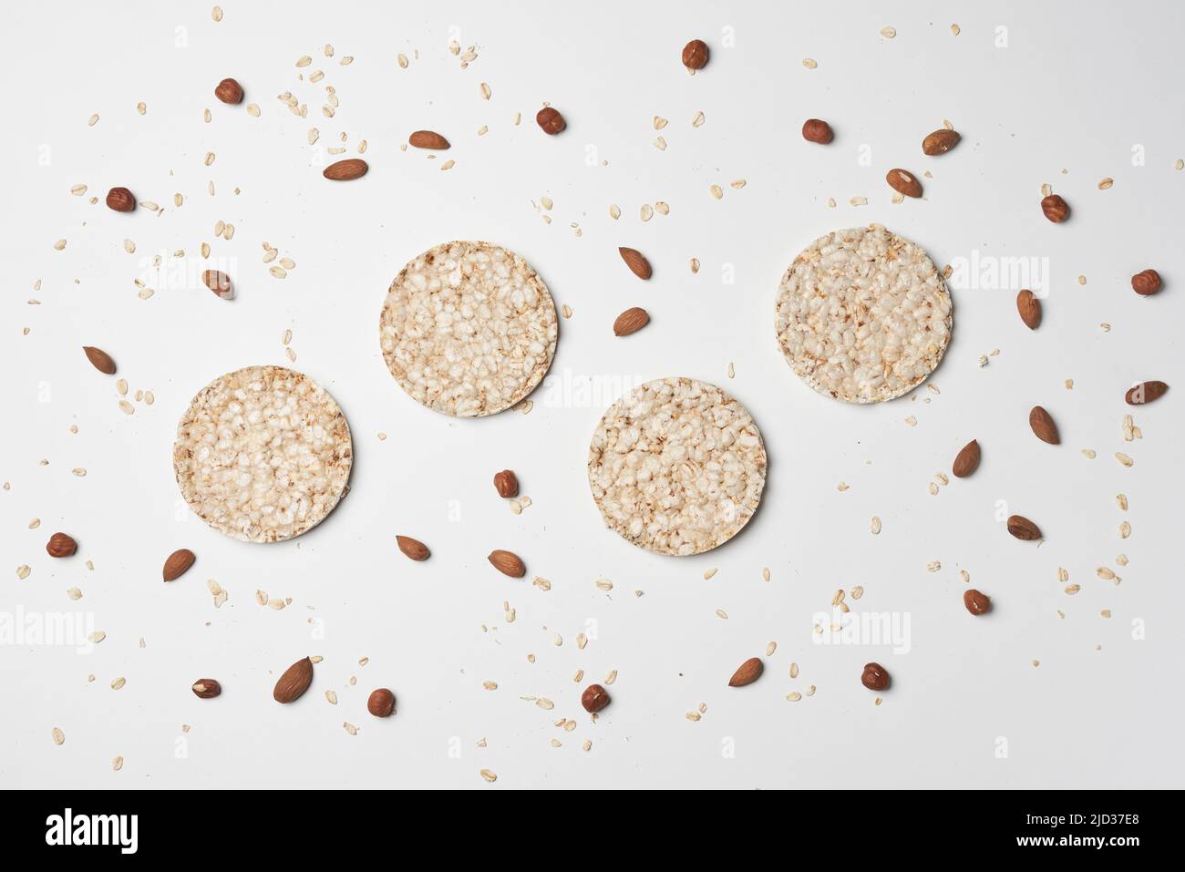 Stack of rice cakes, oatmeal and nuts on white background. Healthy ...