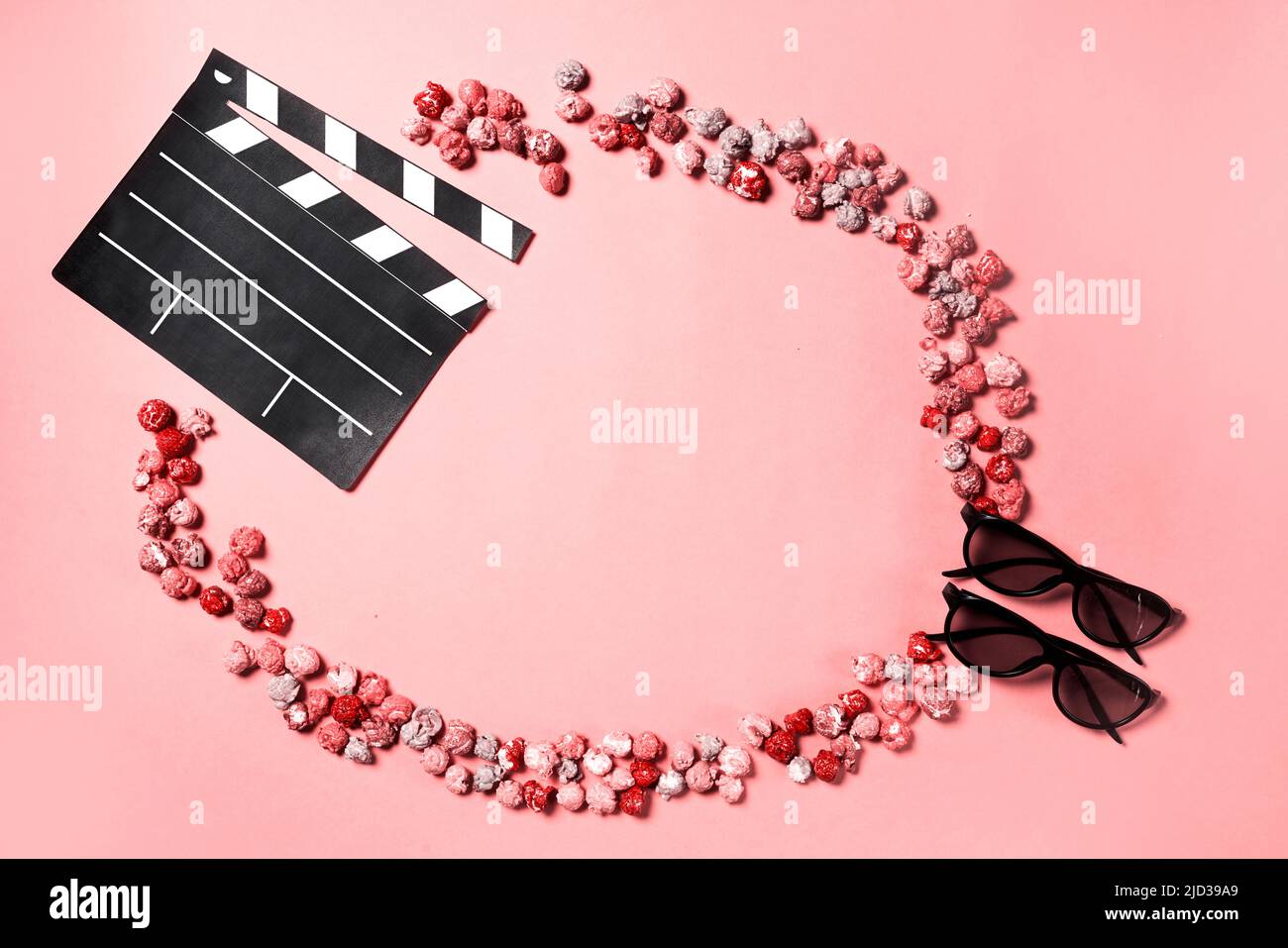 Movie clapper, pop corn and 3d glasses in a pink background. Flat lay ...