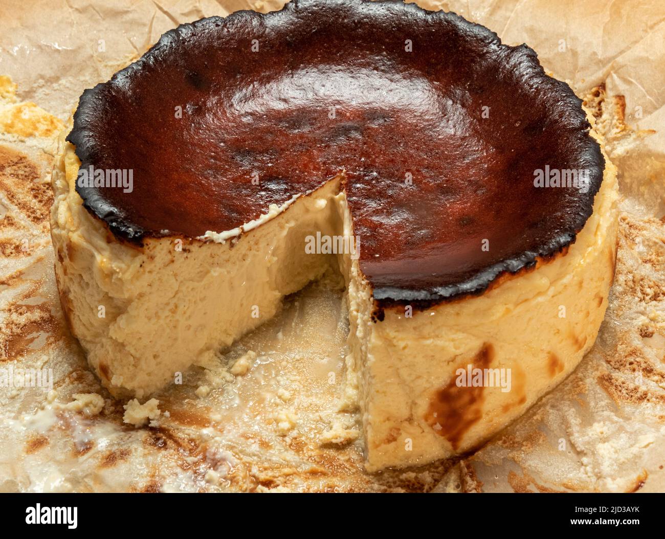 Burnt Basque cheesecake, section removed Stock Photo - Alamy