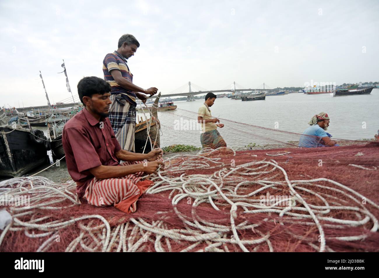 CHATTOGRAM, BANGLADESH,13, 2022 : Fishermen fix fishing nets at an open ...
