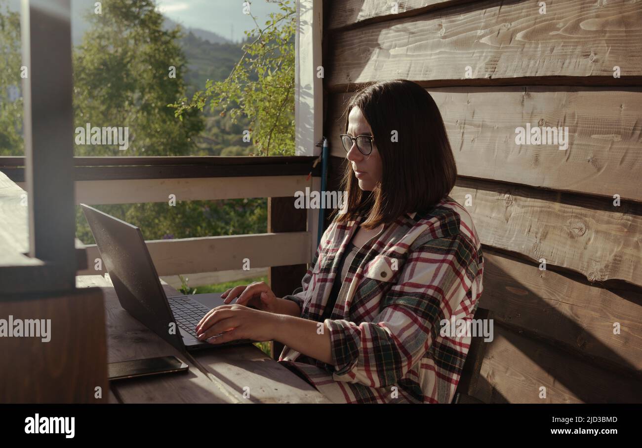Woman wearing eyeglasses working on computer outdoor Stock Photo - Alamy