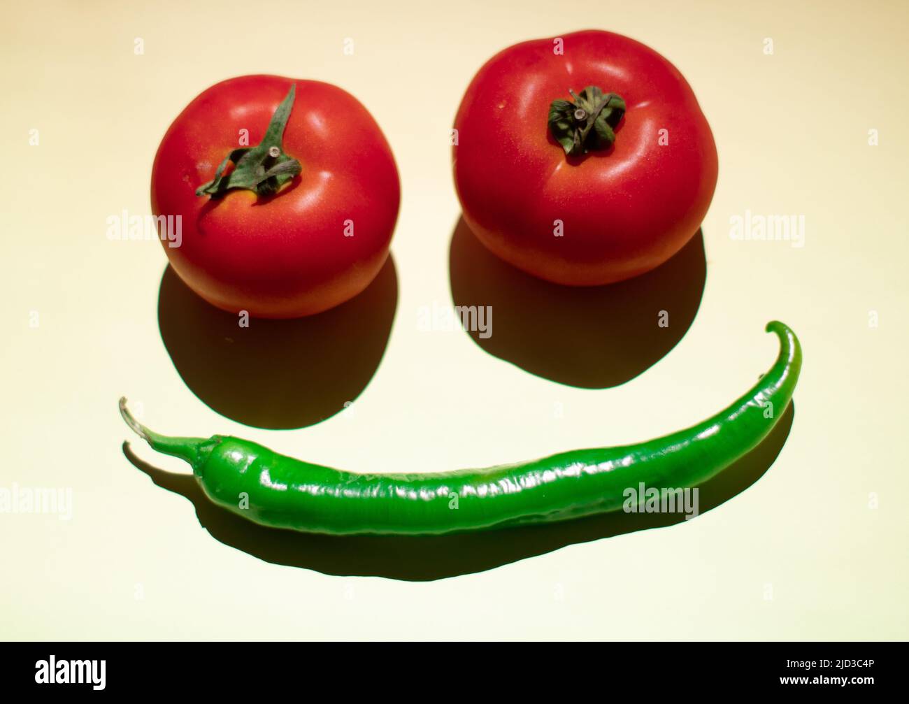 Two tomatoes and a pepper Stock Photo - Alamy