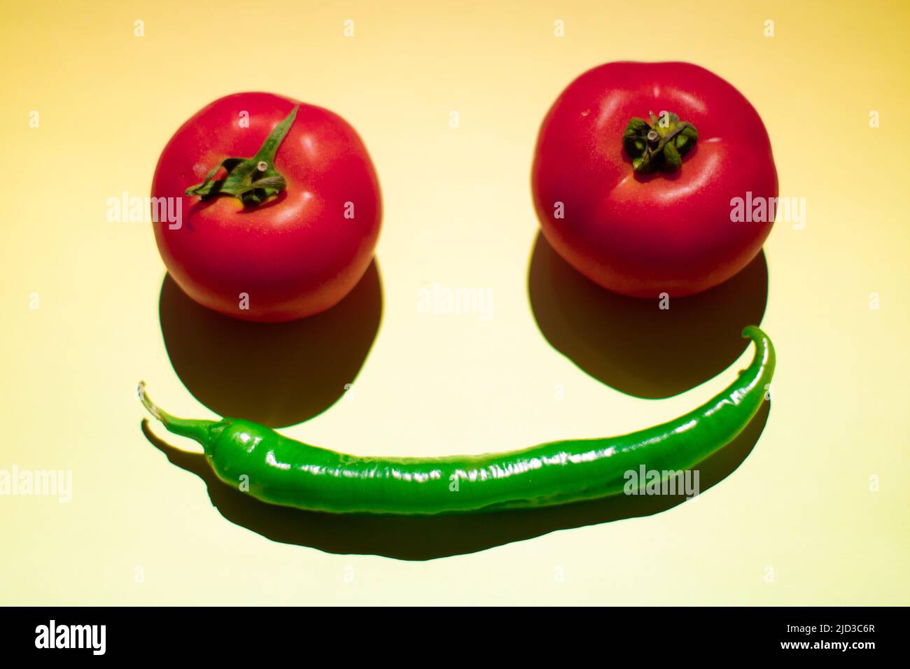 Two tomatoes and a pepper Stock Photo - Alamy