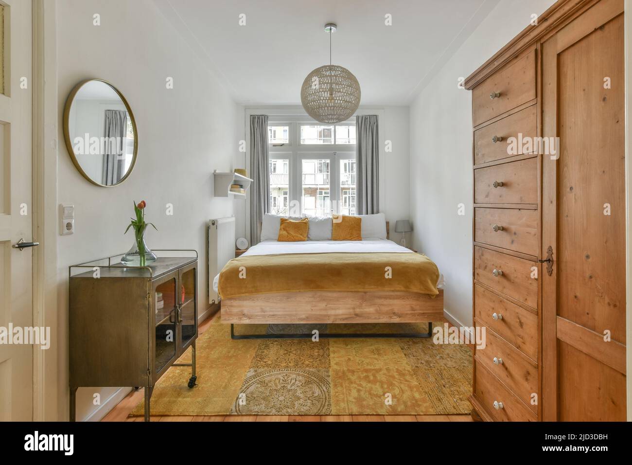 A spacious bright bedroom with a vintage bedside table and a large ...