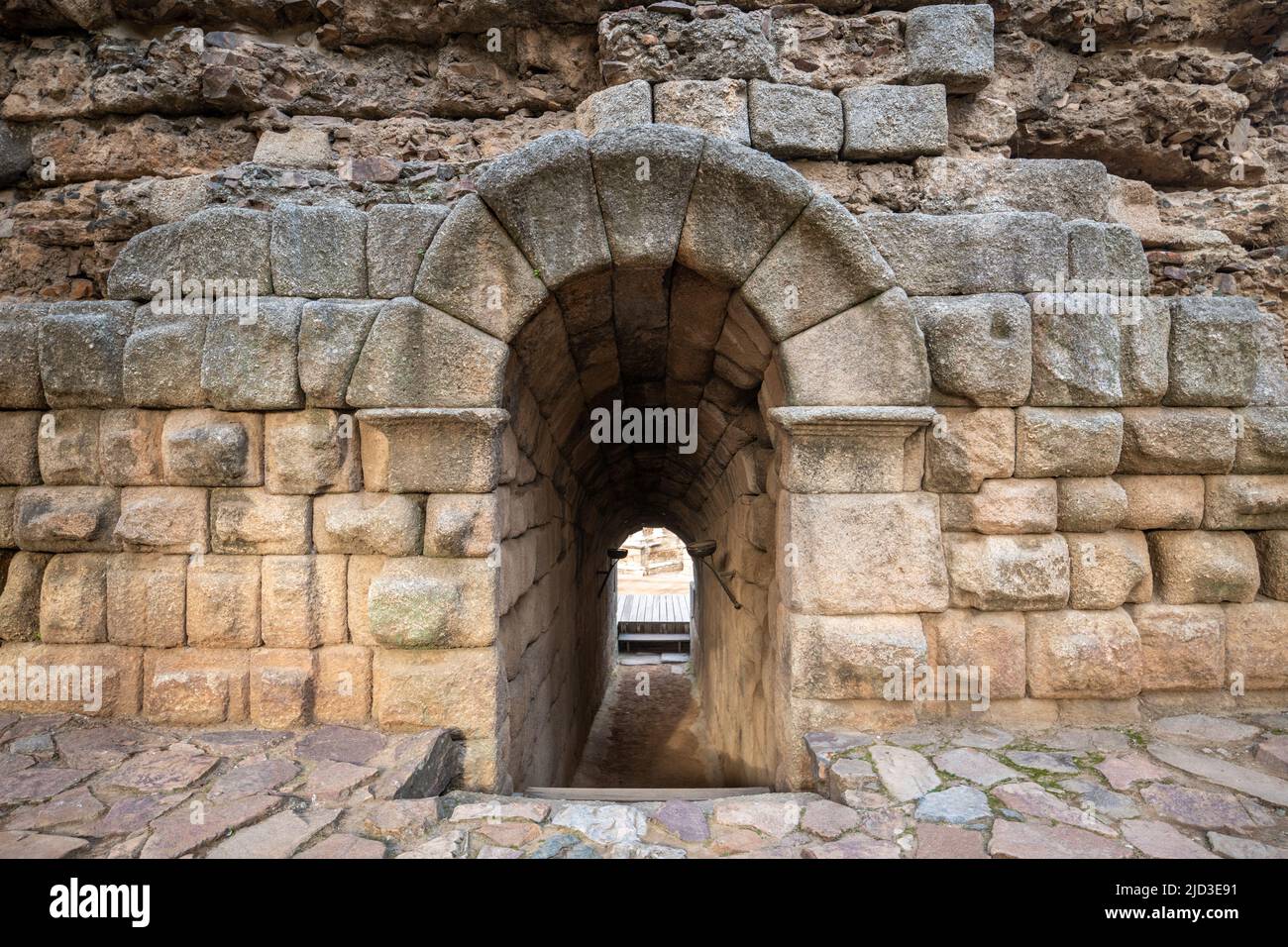 An arched stone pathway leading into the Roman Theatre of Merida ...