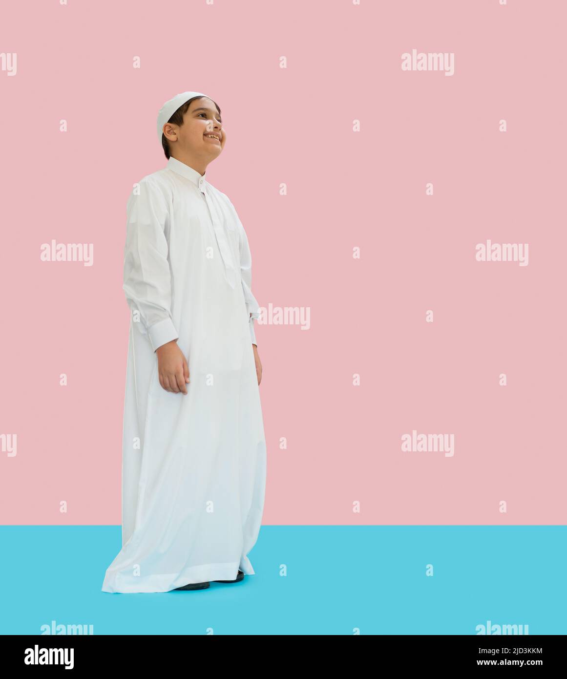 Arabic boy in traditional clothes on blue and pink background, smiling ...