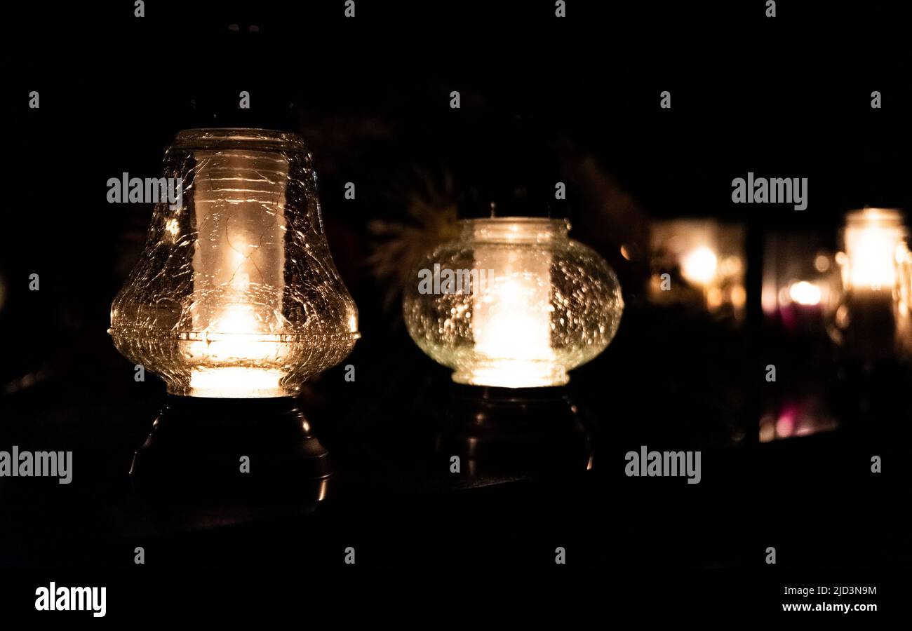 All Saints Day. Night at the cemetery. Candle flame at night on the ...