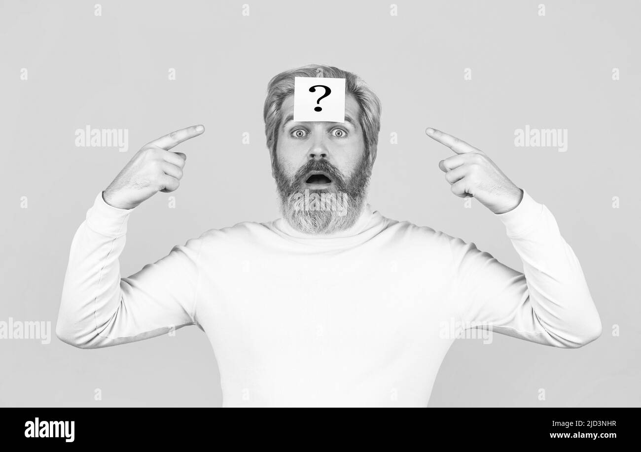 Man with question mark on forehead looking up. Paper notes with ...