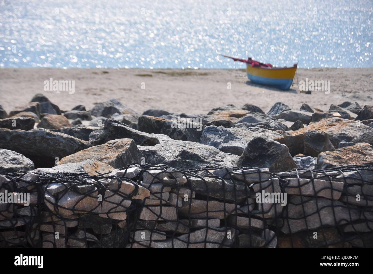 Large stones in the fishing net on the background of the sea coast ...