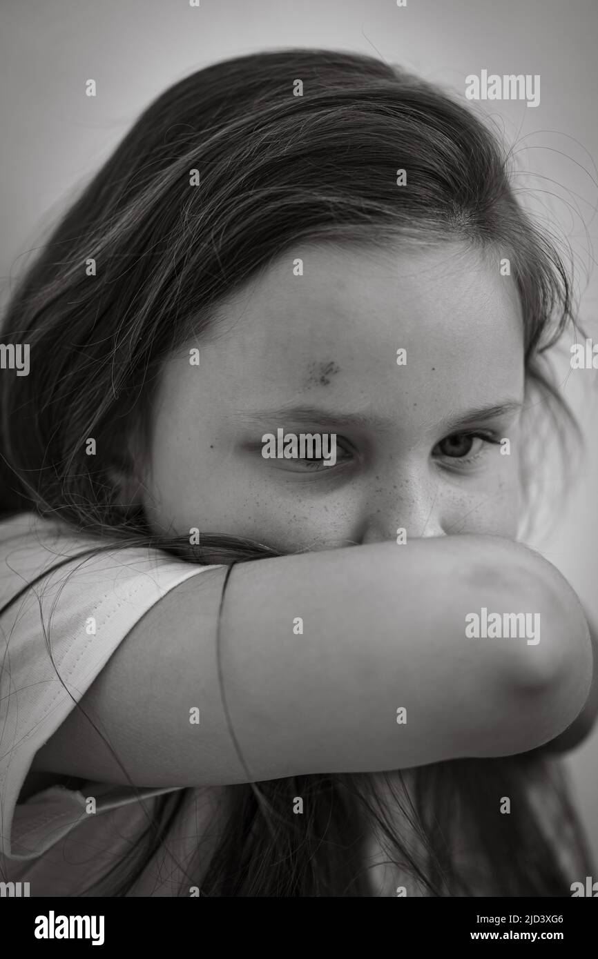 Black and white portrait of little sad fearful injured girl with long ...