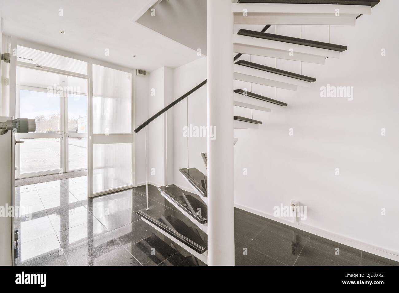 Narrow corridor with white walls and doors leading to the street and ...