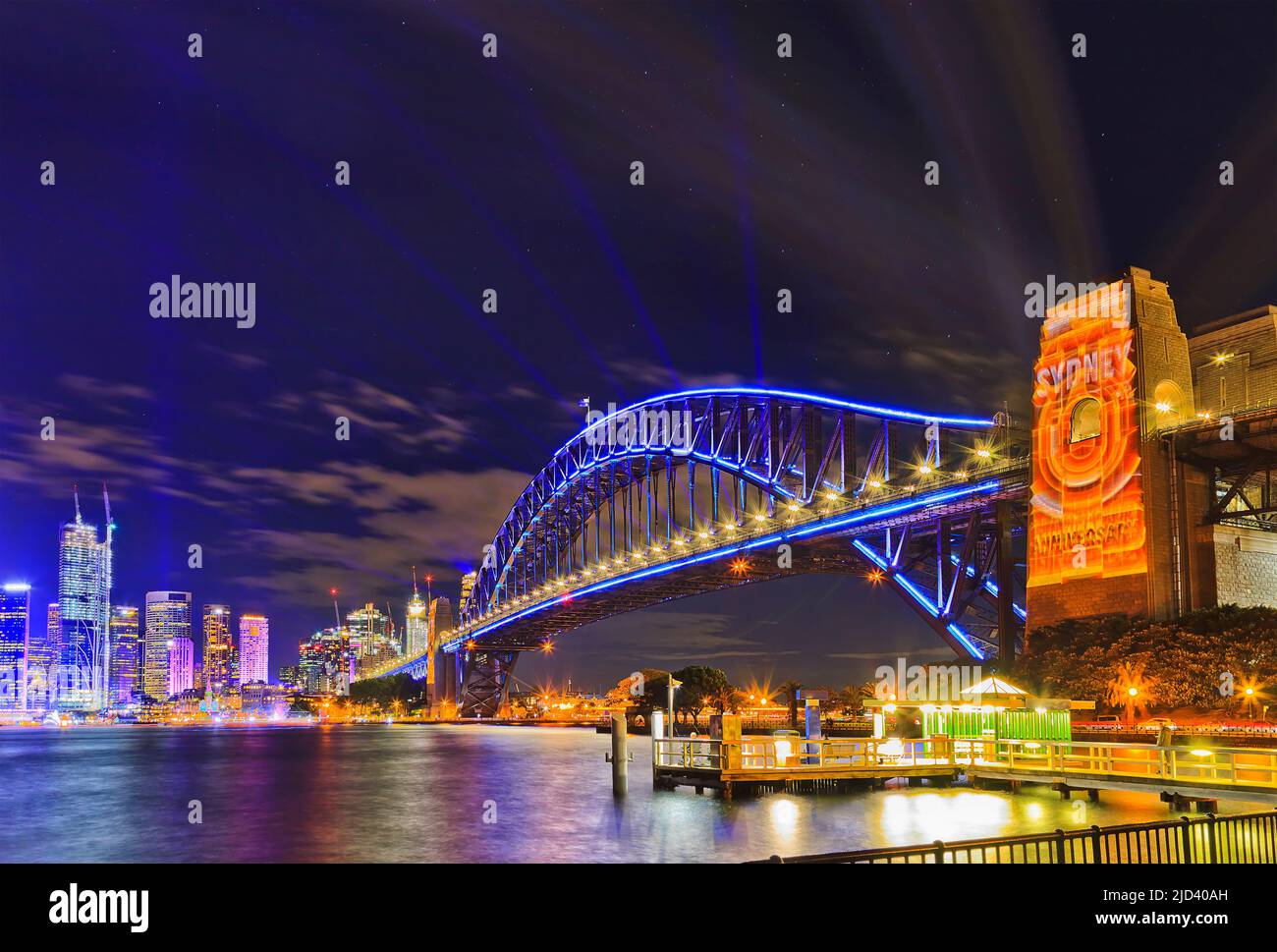Bright illuminated Sydney Harbour bridge with side projection of light ...