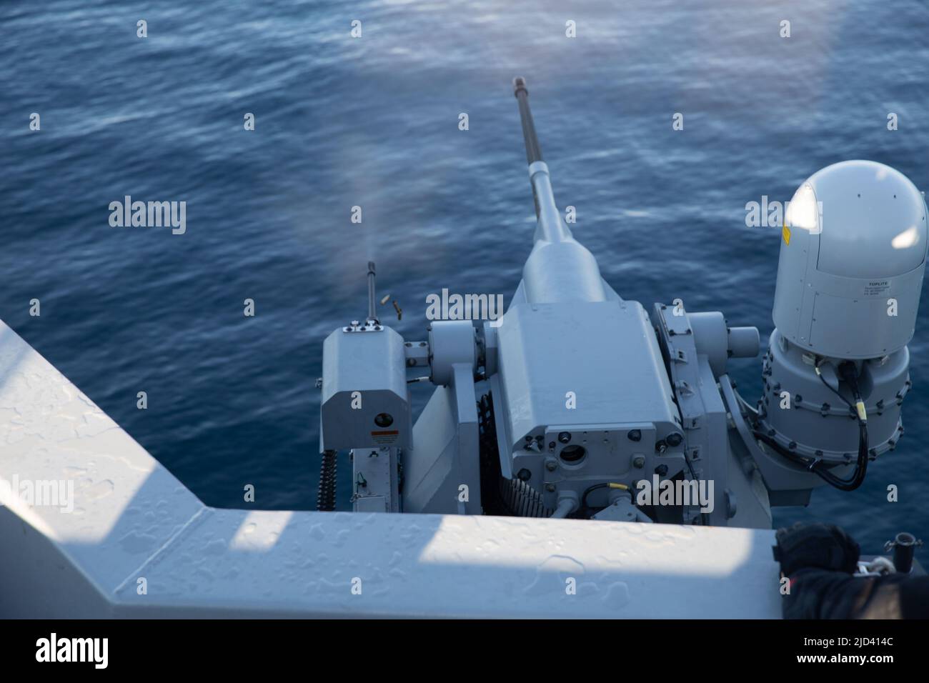 An MK 38 - 25 mm machine gun system fires its coaxial gun off USS ...