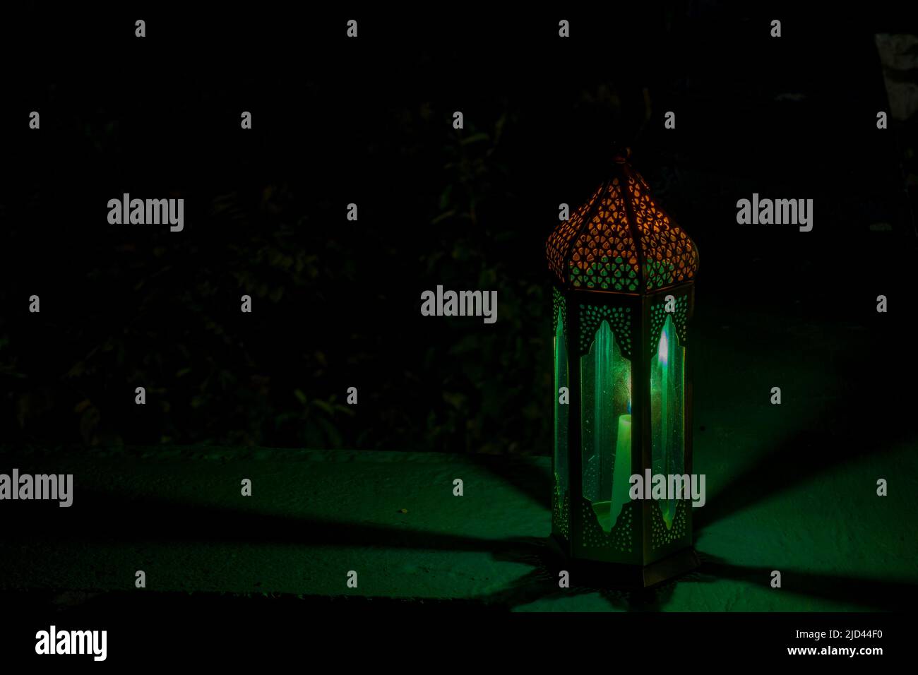 Ornamental Arabic lantern with a burning candle glowing at night ...