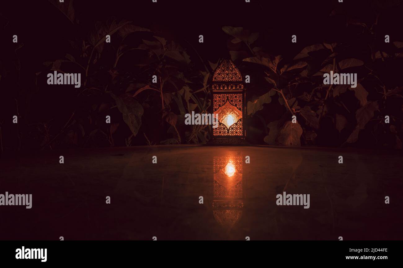Ornamental Arabic lantern with a burning candle glowing at night ...