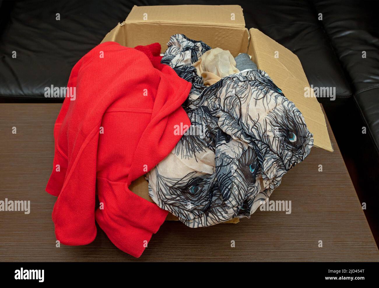 Pile of clothes inside cardboard box ready for moving house Stock Photo ...