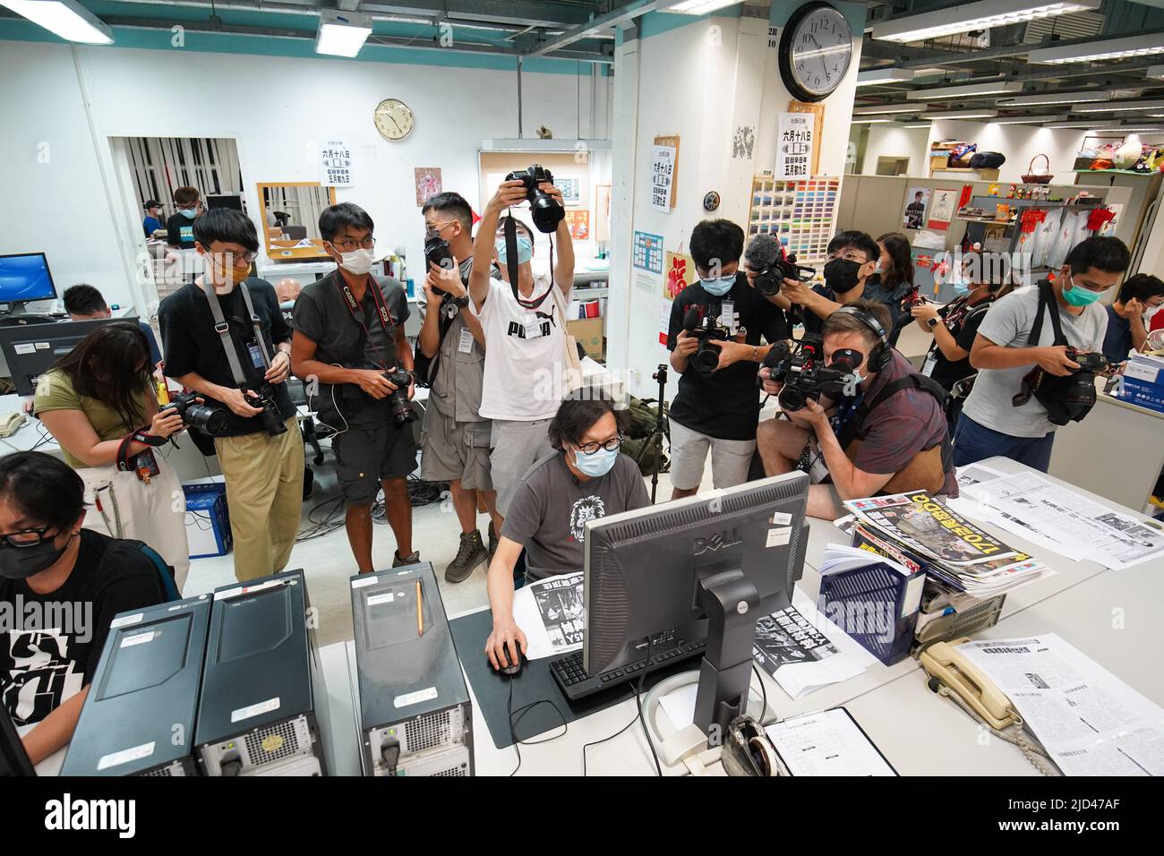 Journalists of Apple Daily seen at work inside their headquarters after ...