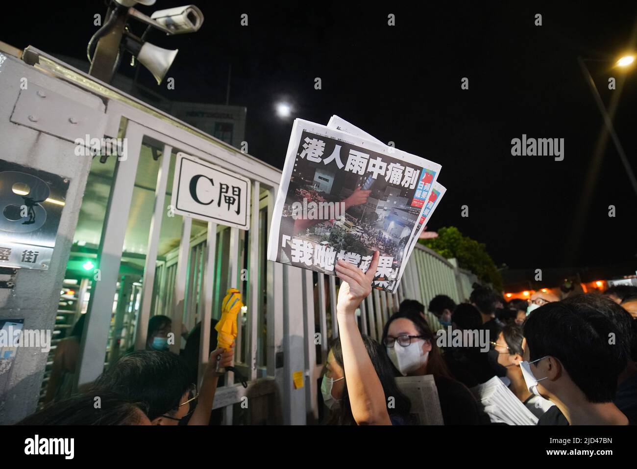 A supporter holds the last edition of Apple Daily newspaper outside the ...