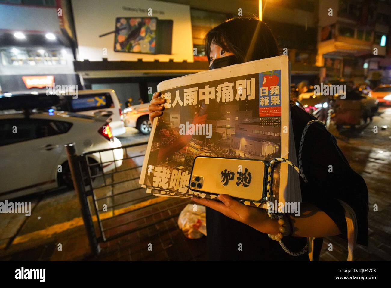 A supporter holds the last edition of Apple Daily newspaper outside the ...