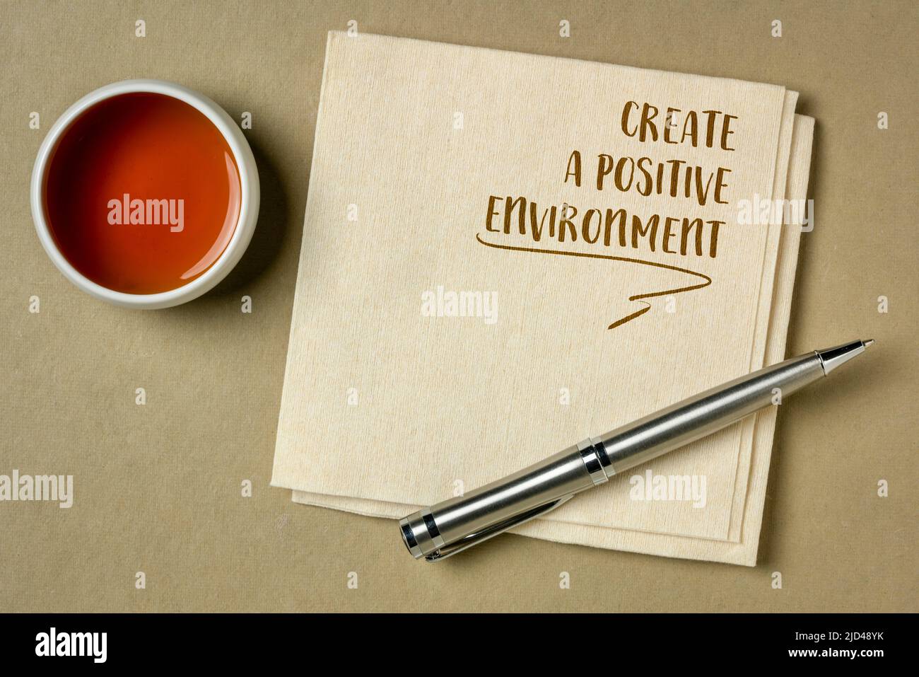create a positive environment, inspirational reminder note on a napkin ...