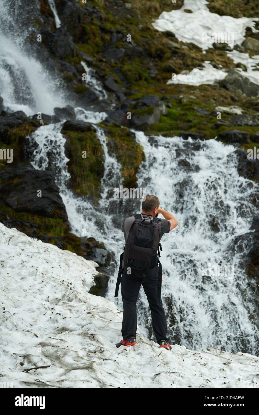 Nature photographer shooting a waterfall through the snow Stock Photo ...