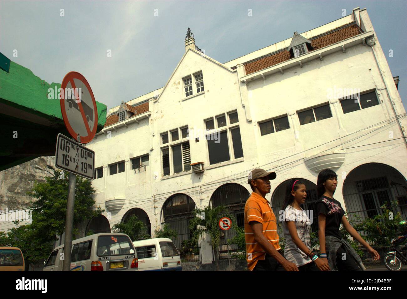 Street walkers in a background of road traffic and an old building in ...