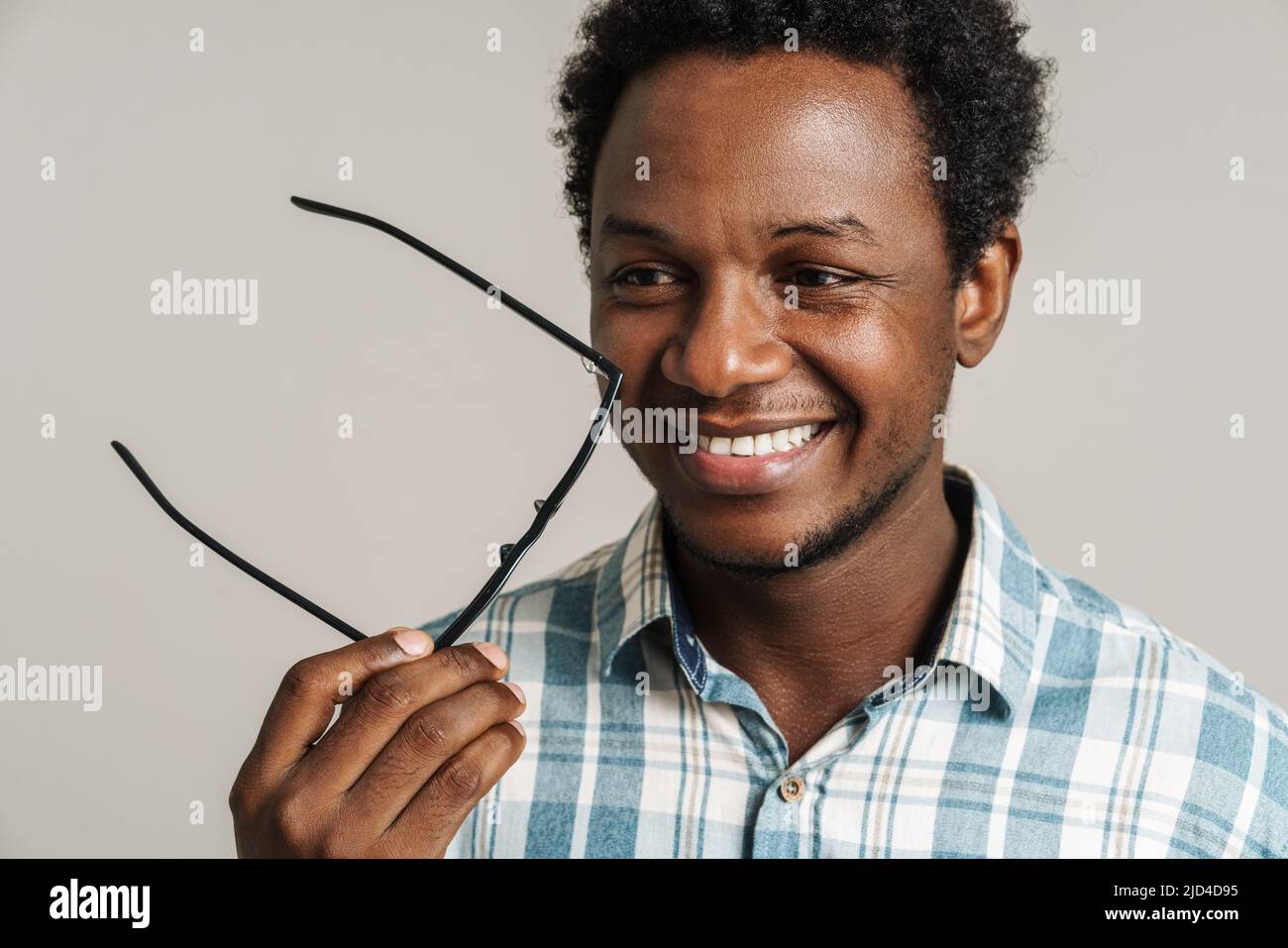 Black unshaven man smiling while posing with eyeglasses isolated over ...