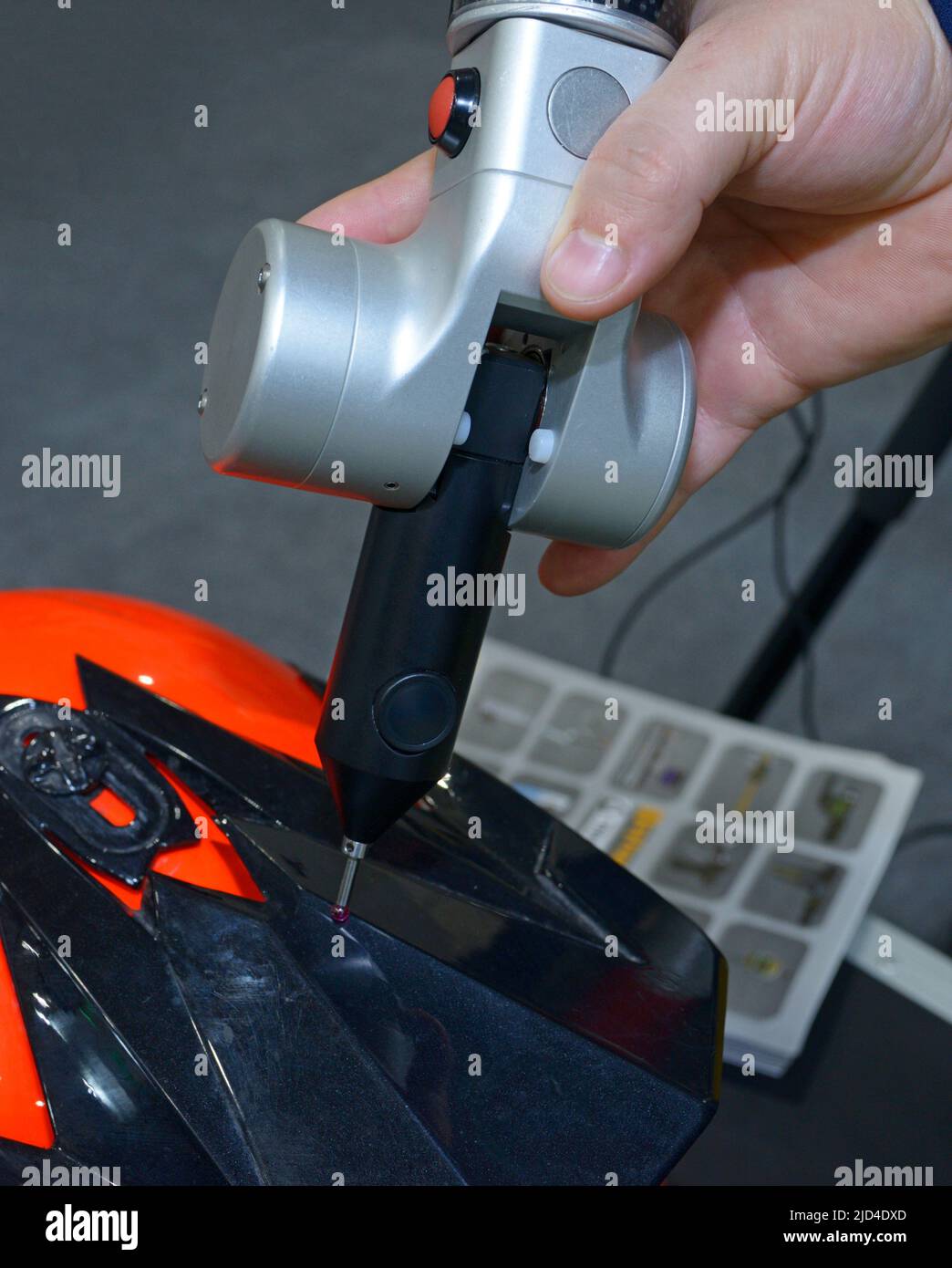 Worker hand holding the probe of measuring machine to measure hole in ...