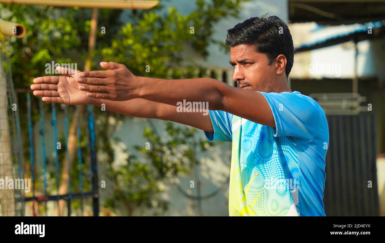 Athletic Rajasthani man in a sporty uniform engaged in yoga at outdoor ...