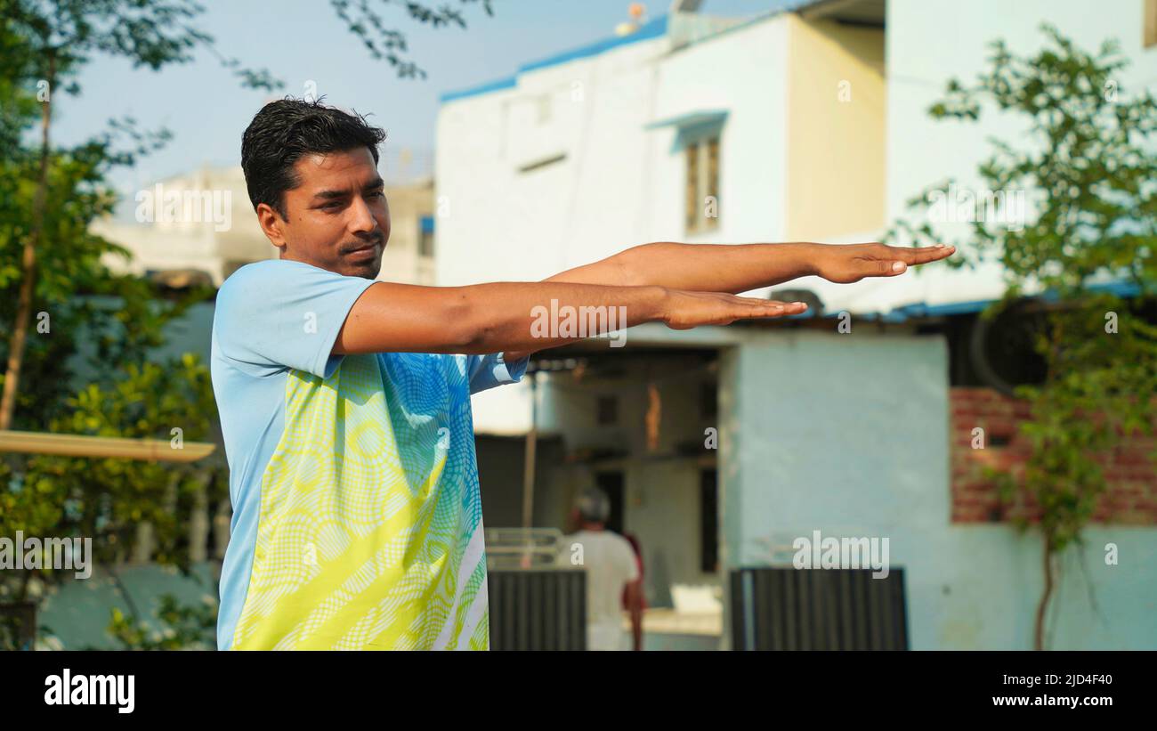 Athletic Rajasthani man in a sporty uniform engaged in yoga at outdoor ...