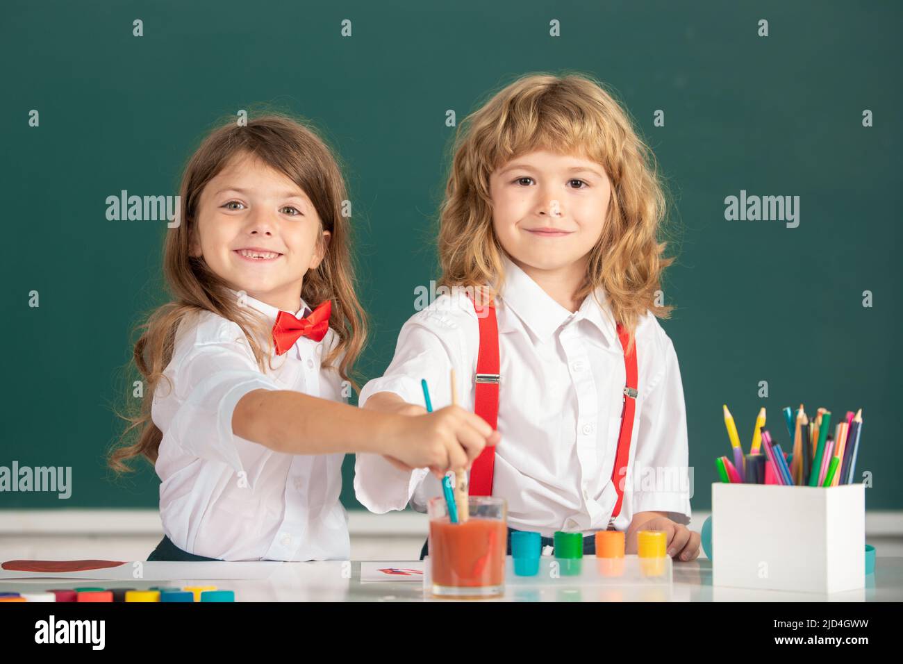 School children drawing a colorful pictures with pencil crayons in ...