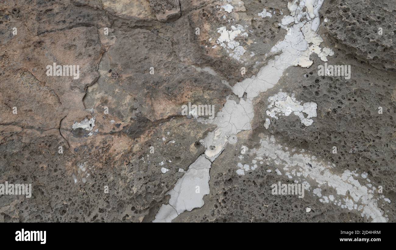 Volcanogenic rock slabs on the seashore. Natural rocky breakwater at ...