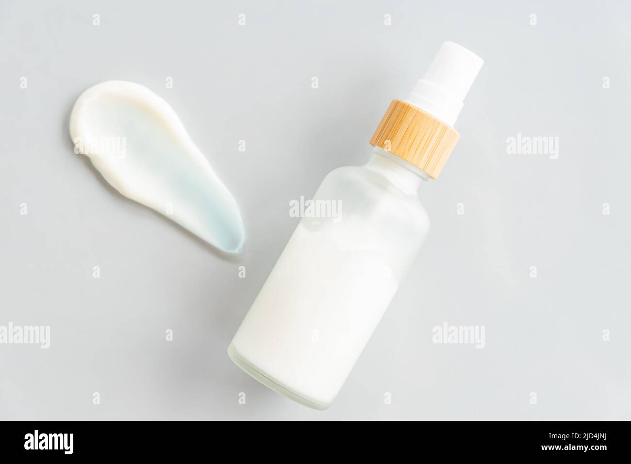 Frosted glass bottle of moisturizer cream on gray background. Natural ...