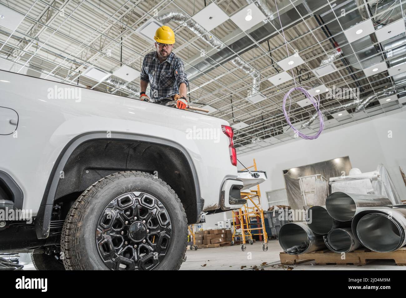Male Construction Worker Standing in the Trunk of a Pickup Truck and ...