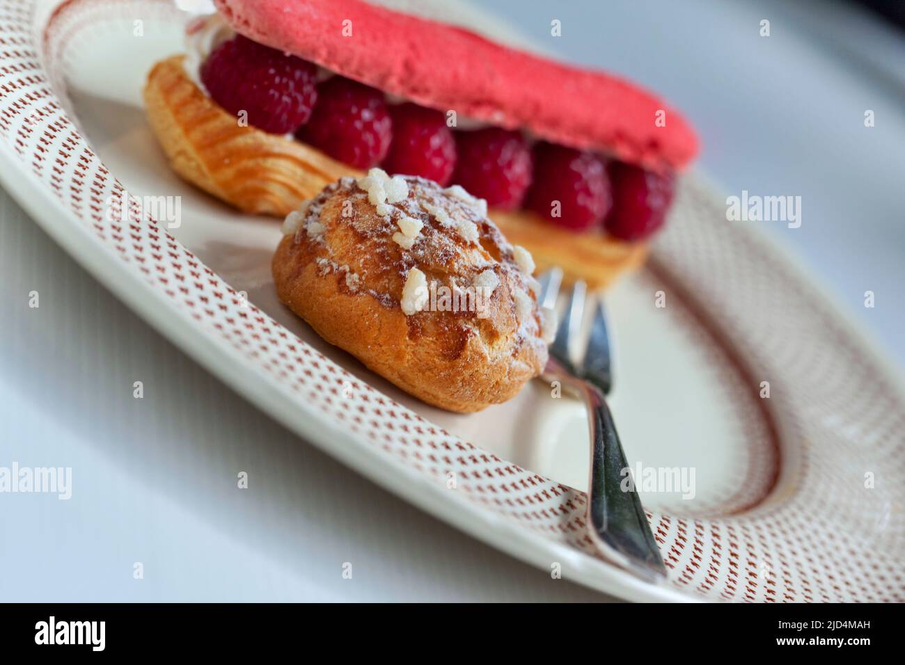 Puff pastry and Raspberry Eclair on a plate Stock Photo - Alamy