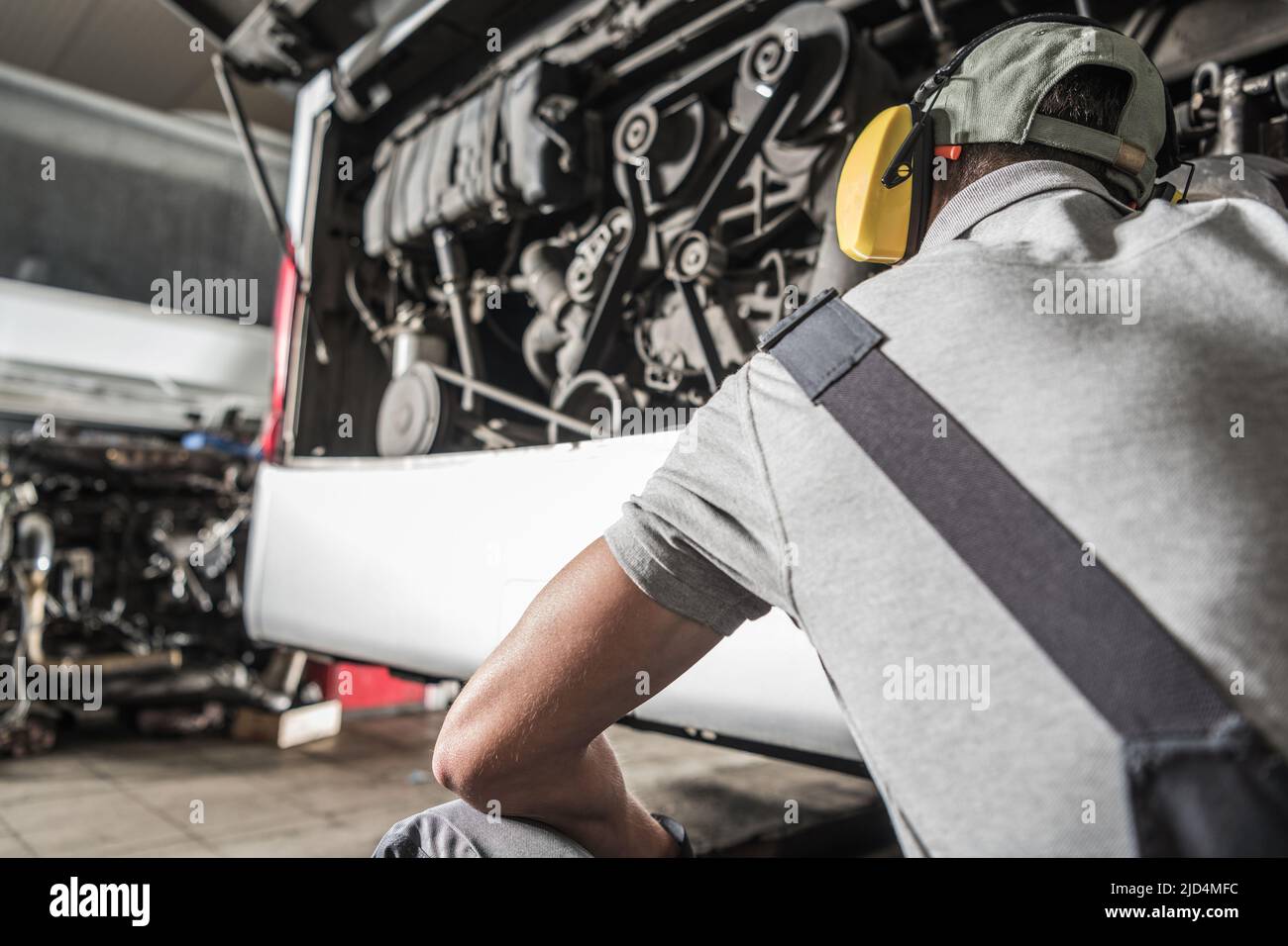 Mechanic Looking at the Diesel Engine of a Large Coach Bus Searching ...
