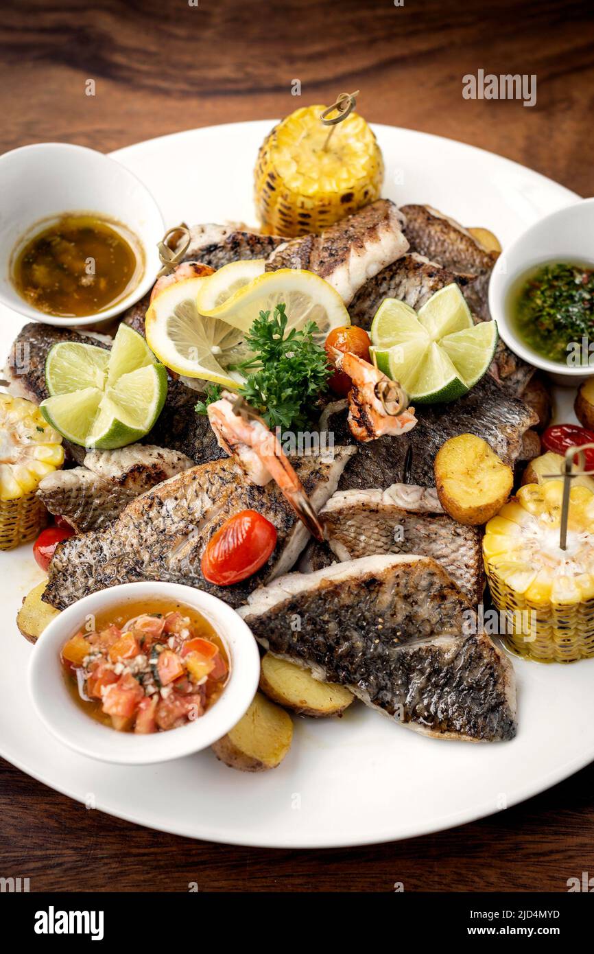 mixed fried fish plate with seared seabass and red snapper on wood ...