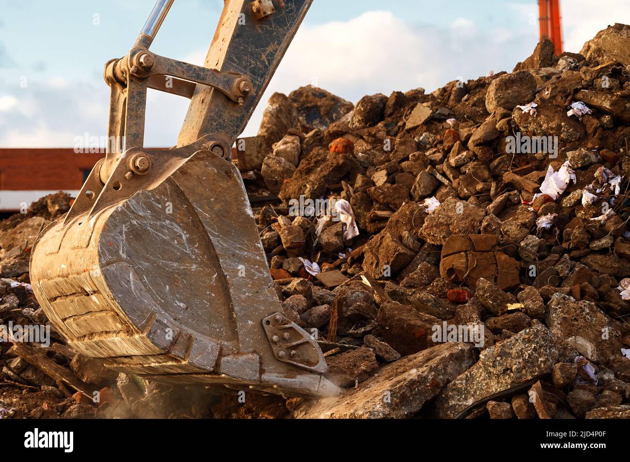 Bucket of excavator digs leftovers of destroyed building Stock Photo ...