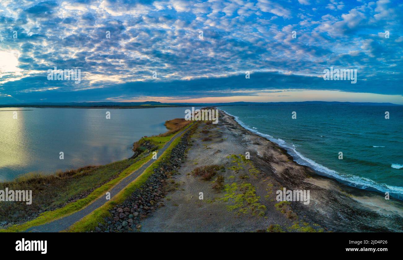 A bird's eye view panorama of a wild sandy dry grass shore washed by a ...