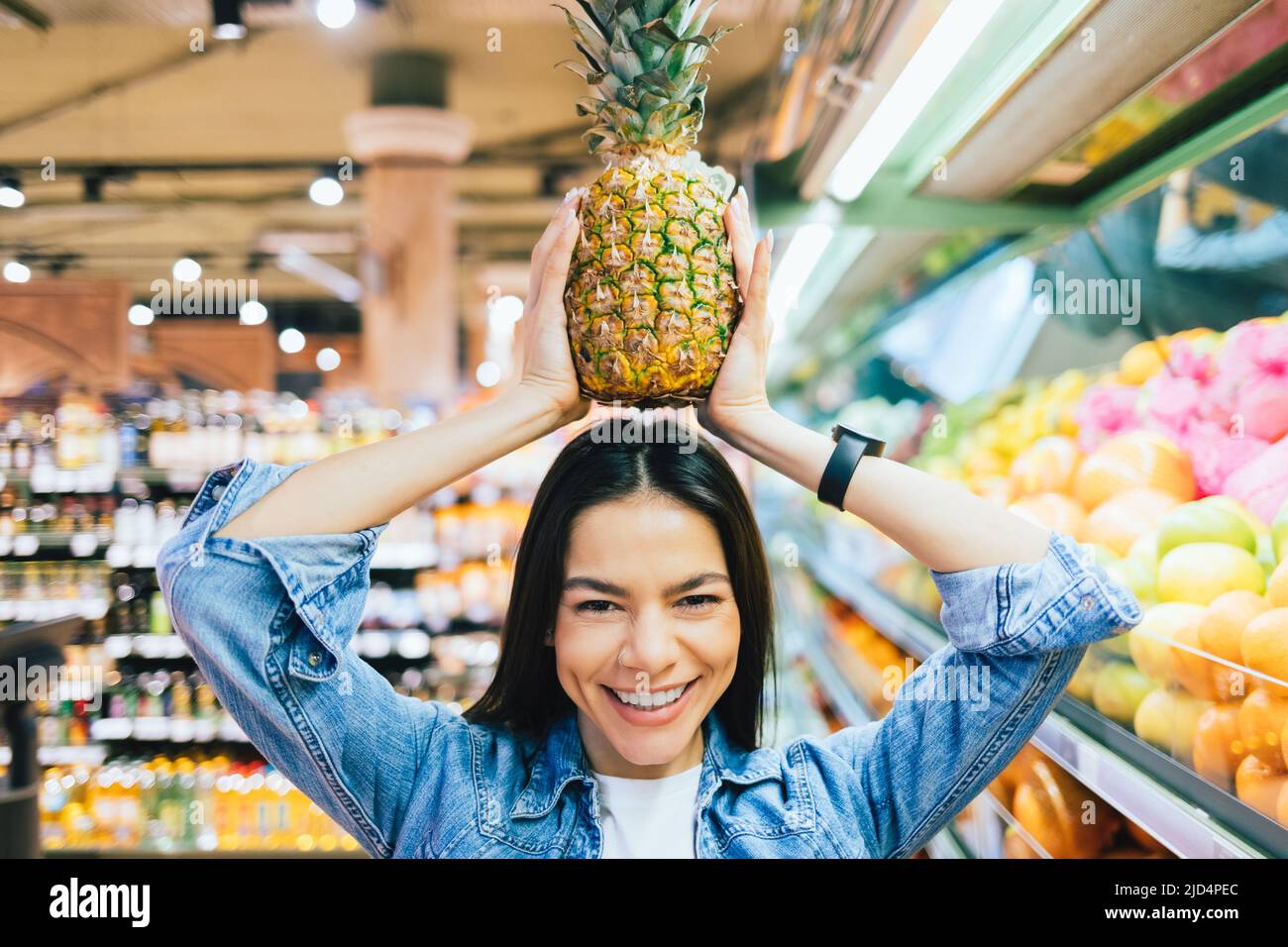 Portrait funny cheerful young woman shopping at supermarket holding ...