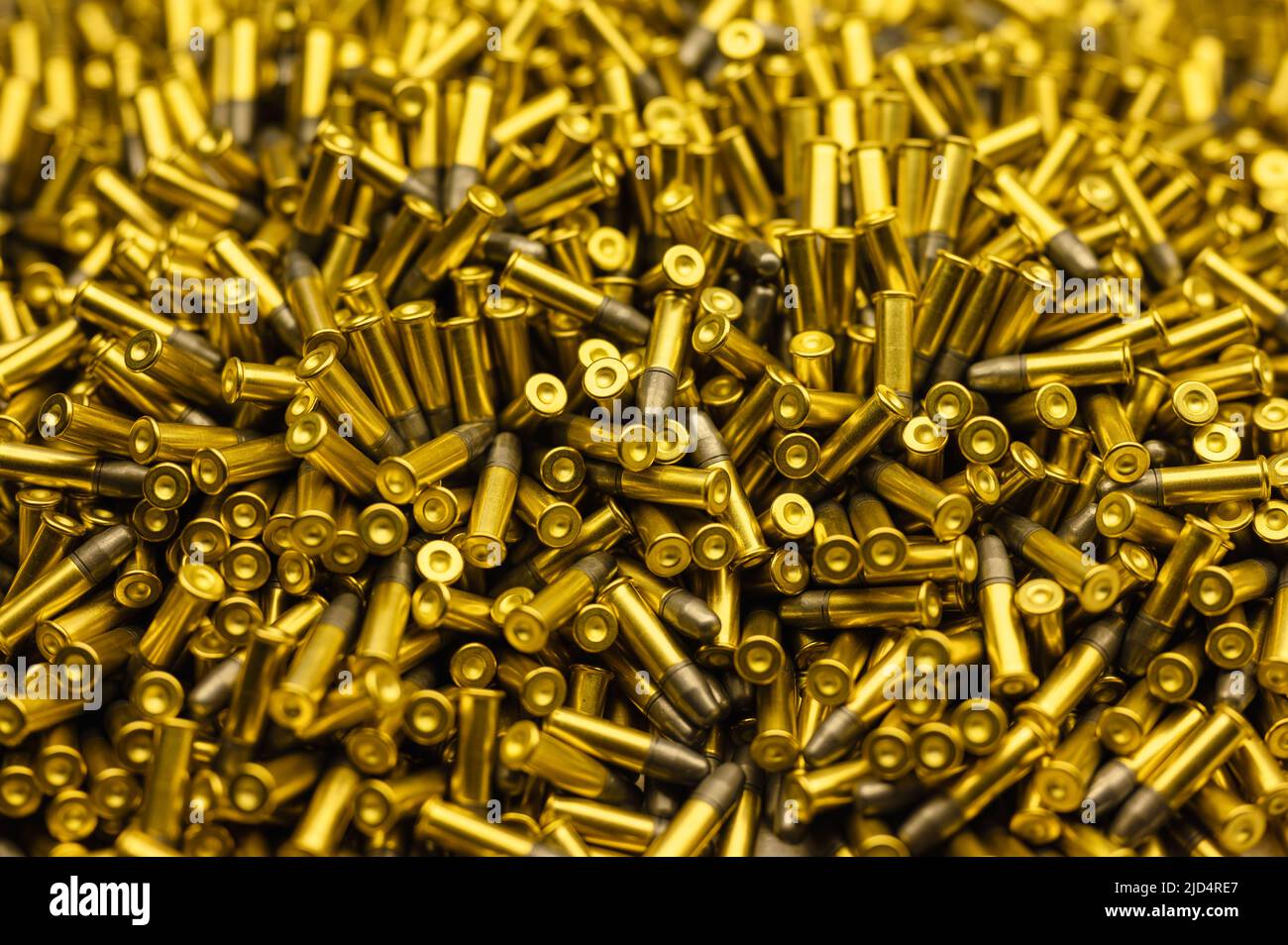 Heap of black and golden small-caliber bullets on table Stock Photo - Alamy