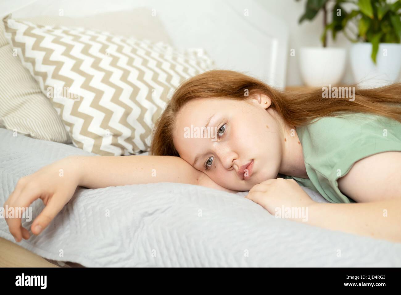 Thoughtful girl lying on bed hi-res stock photography and images - Alamy