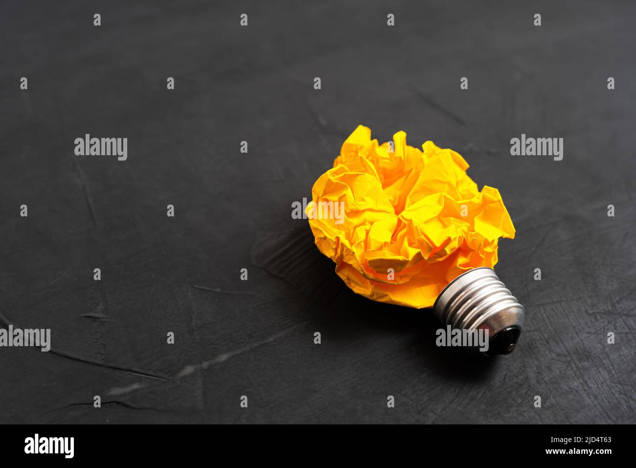 Lightbulb shape made from a crumpled paper ball on black background ...