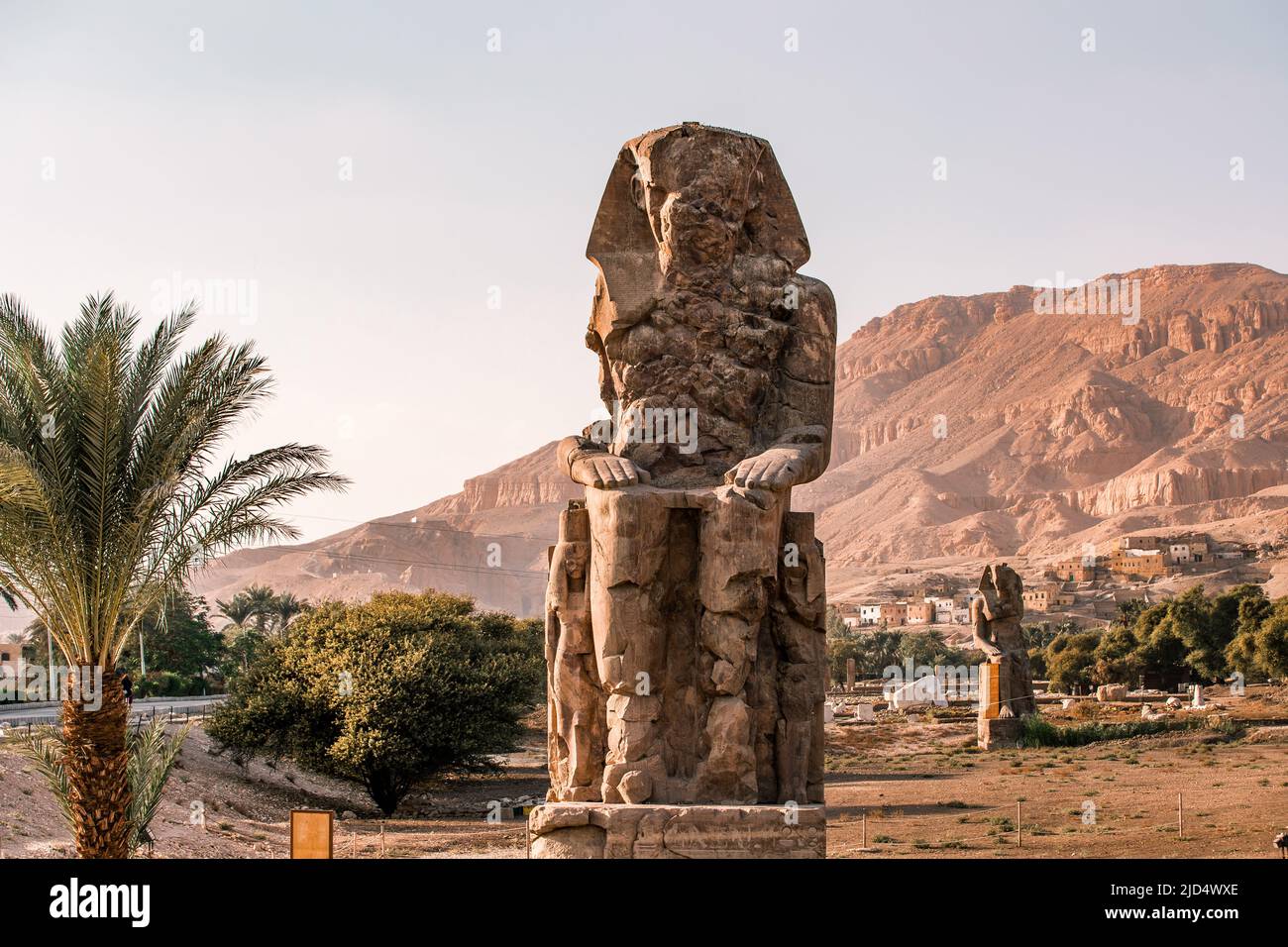 Ancient Egyptian Colossi of Memnon stone pharaoh statue with mountain ...