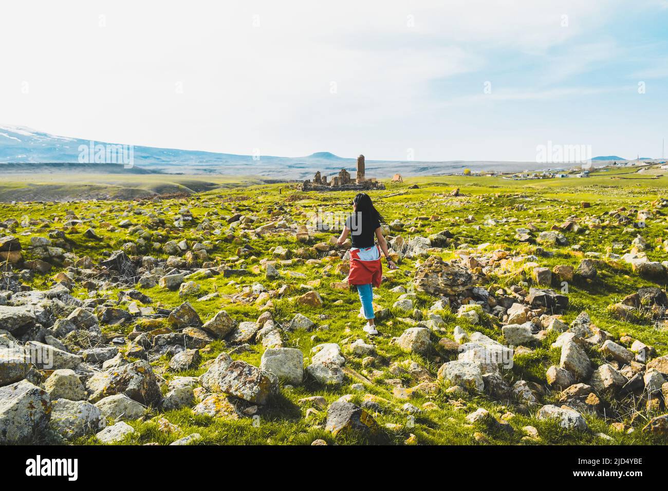 Caucasian female tourist walk around Ani ruins sightseeing in spring ...